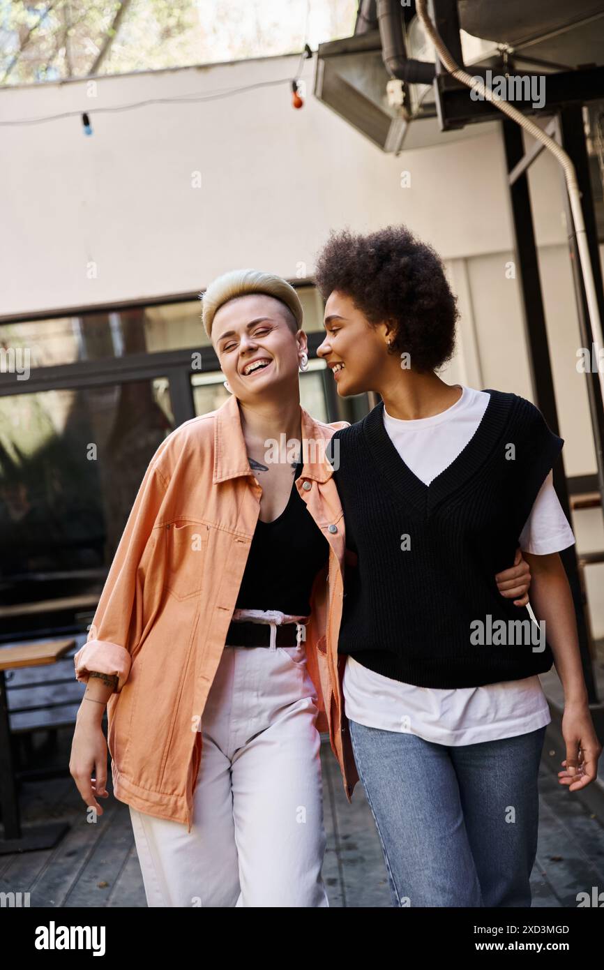Two women walk together down a city street Stock Photo - Alamy