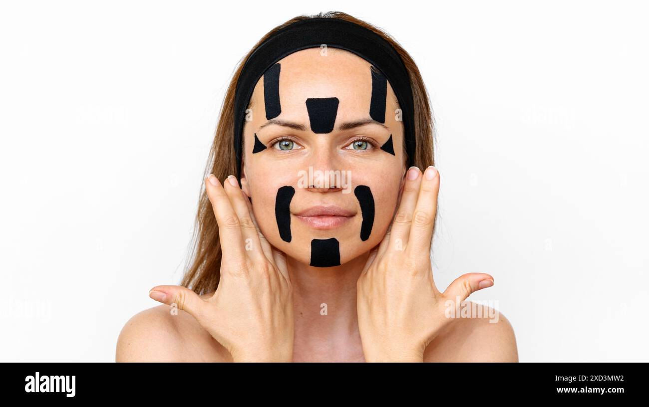 Female beauty model, applying kinesio tapes to her face. Beauty, body ...