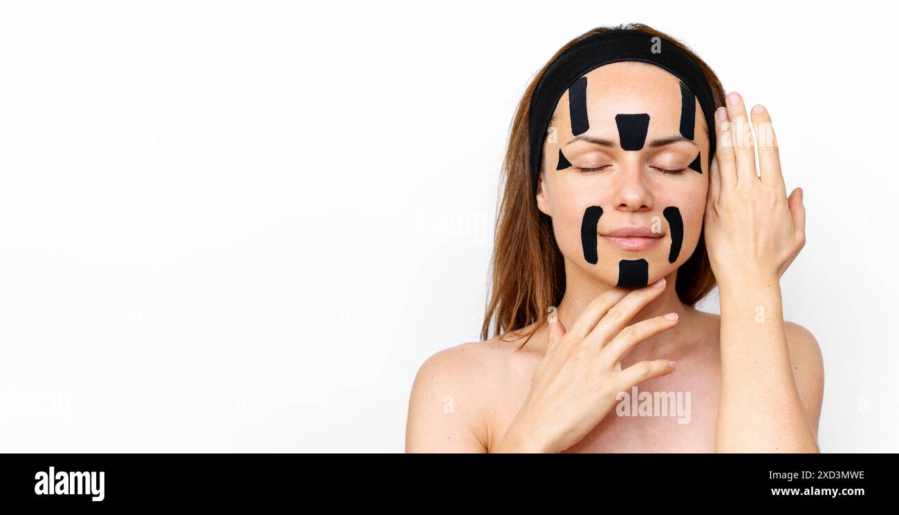 Beauty model, a caucasian brunette woman, applying kinesio tapes to her ...