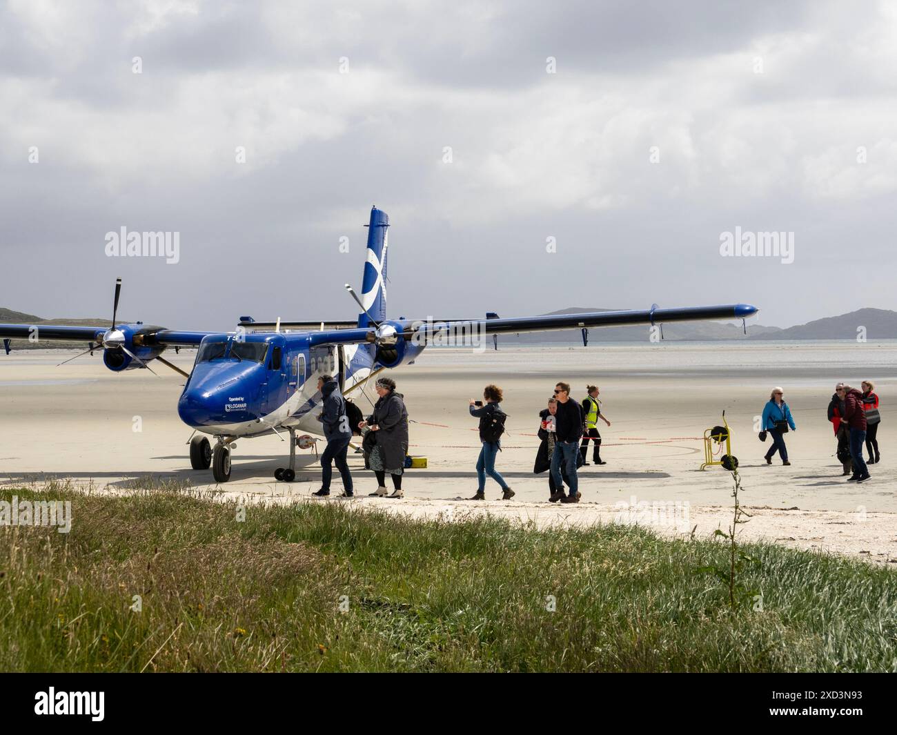 Passengers disembark a plane on Traigh mhor beach at the airport on the ...