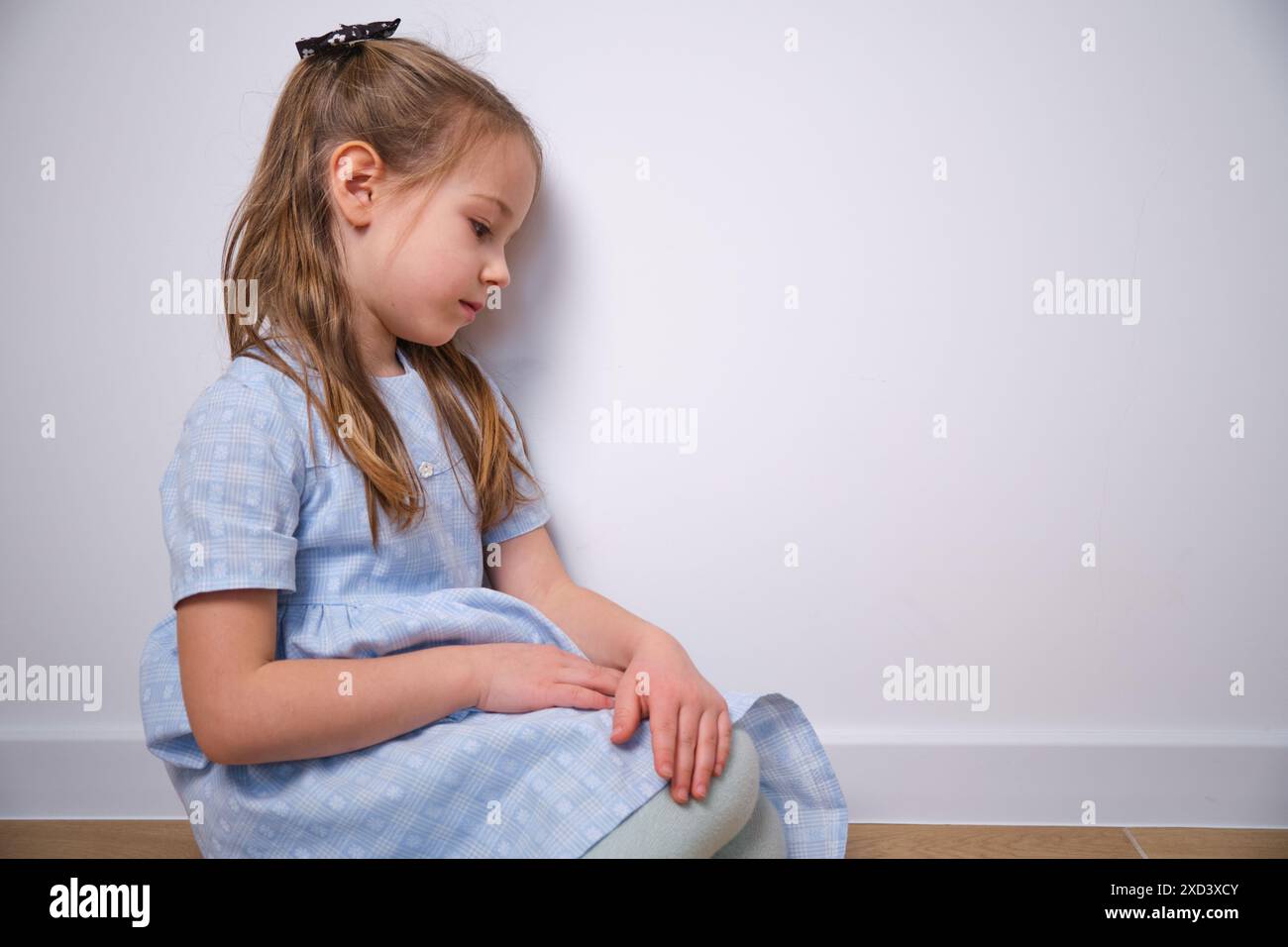 Sad depressed pensive little girl sitting on the floor Stressed unhappy ...