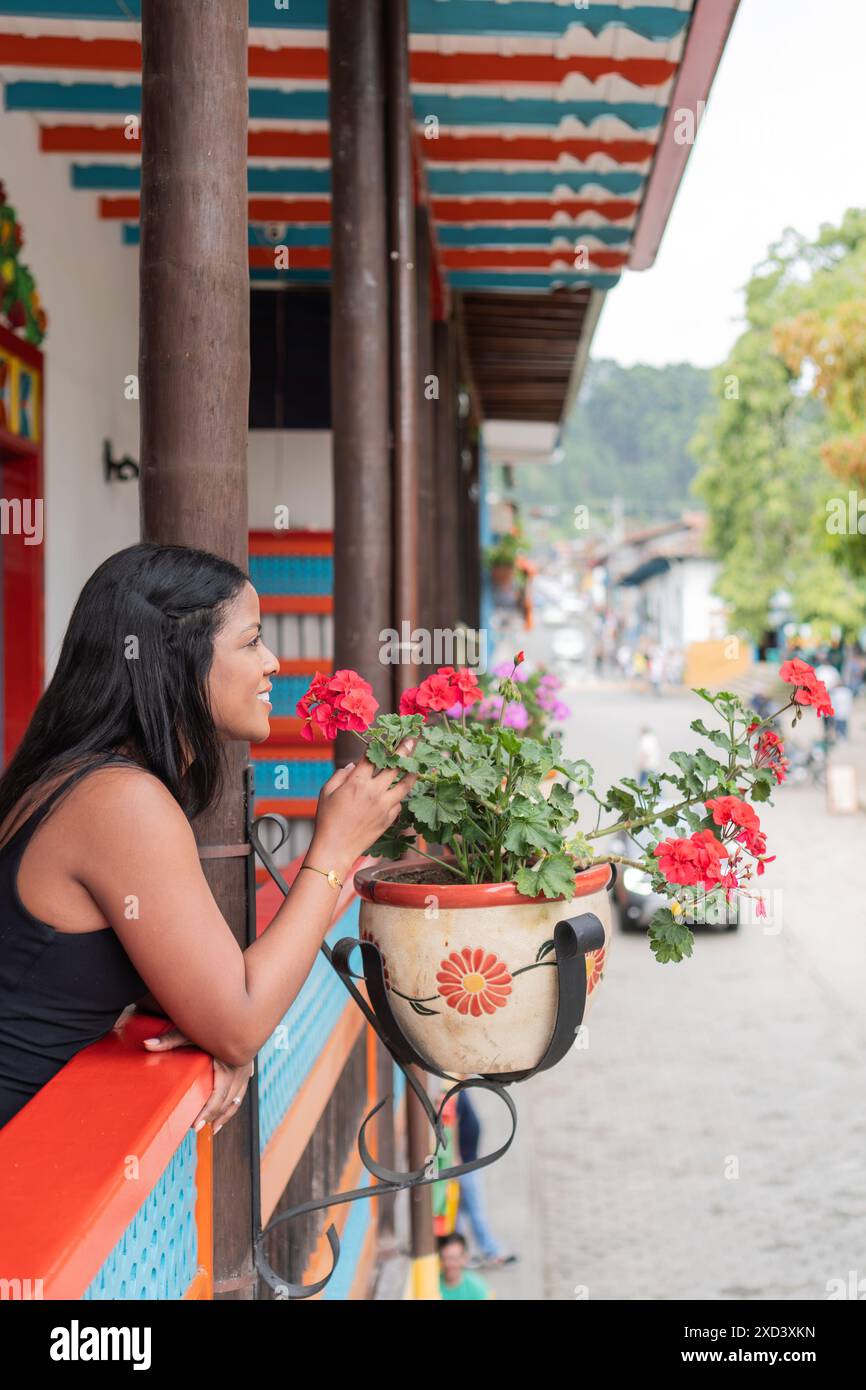 Colombian Woman Enjoying Red Flowers on Traditional Balcony Stock Photo ...