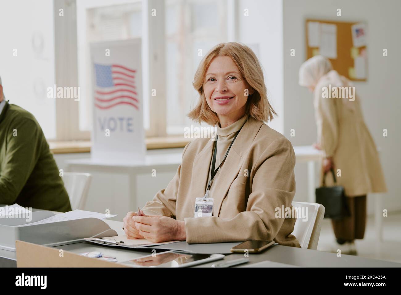 Medium portrait of cheerful mature Caucasian woman sitting at desk at ...