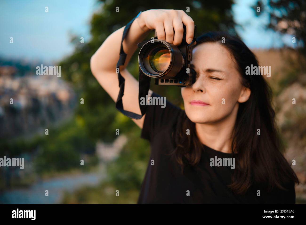 A woman photographer climbed a high hill and photographs the city below ...