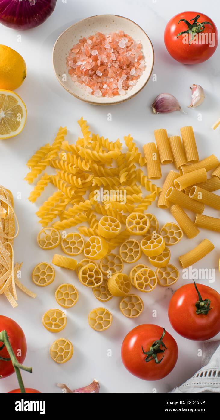 Homemade dry pasta with various ingredients on marble table Stock Photo ...