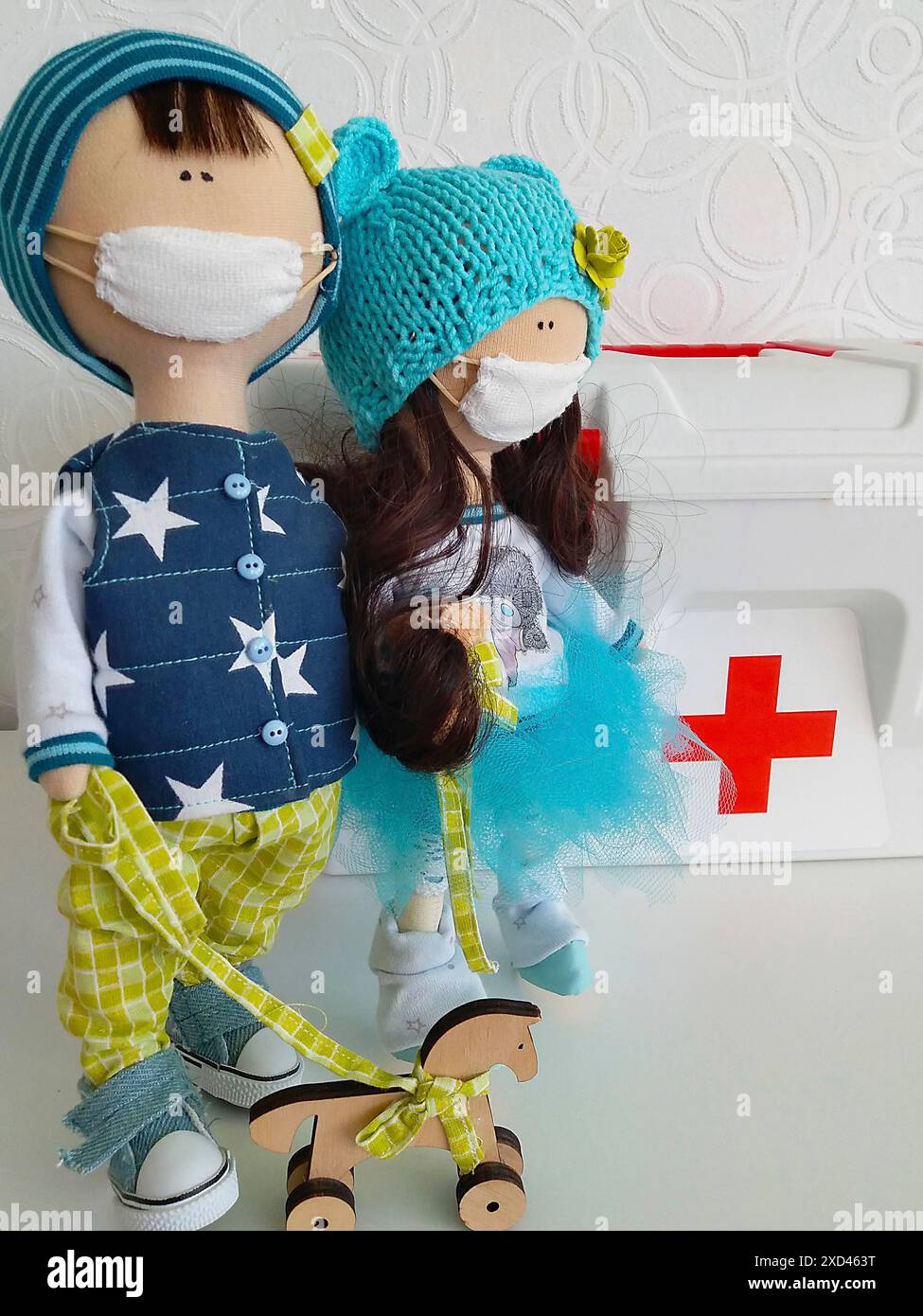 Two dolls wearing face masks, dressed in blue and green with a ...
