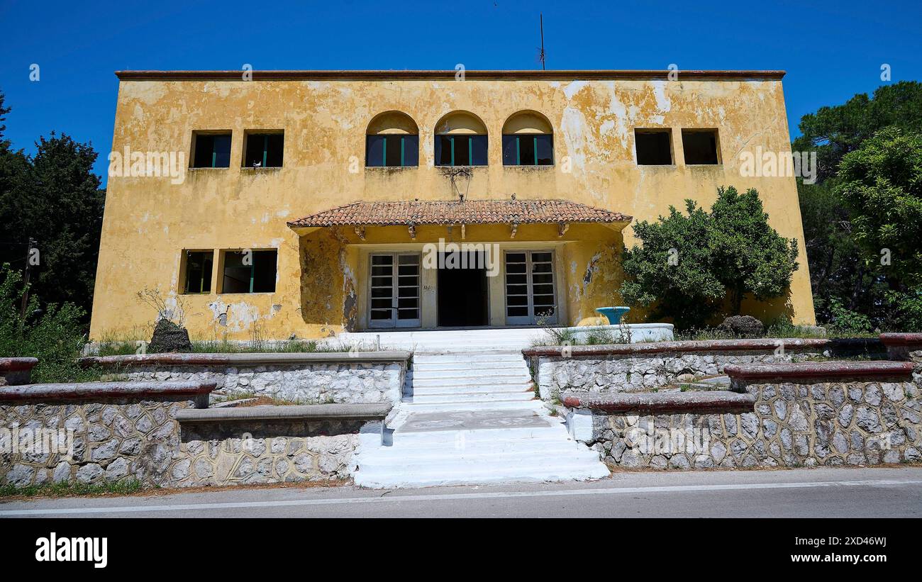 Abandoned yellow two-storey building with damaged facade and ...