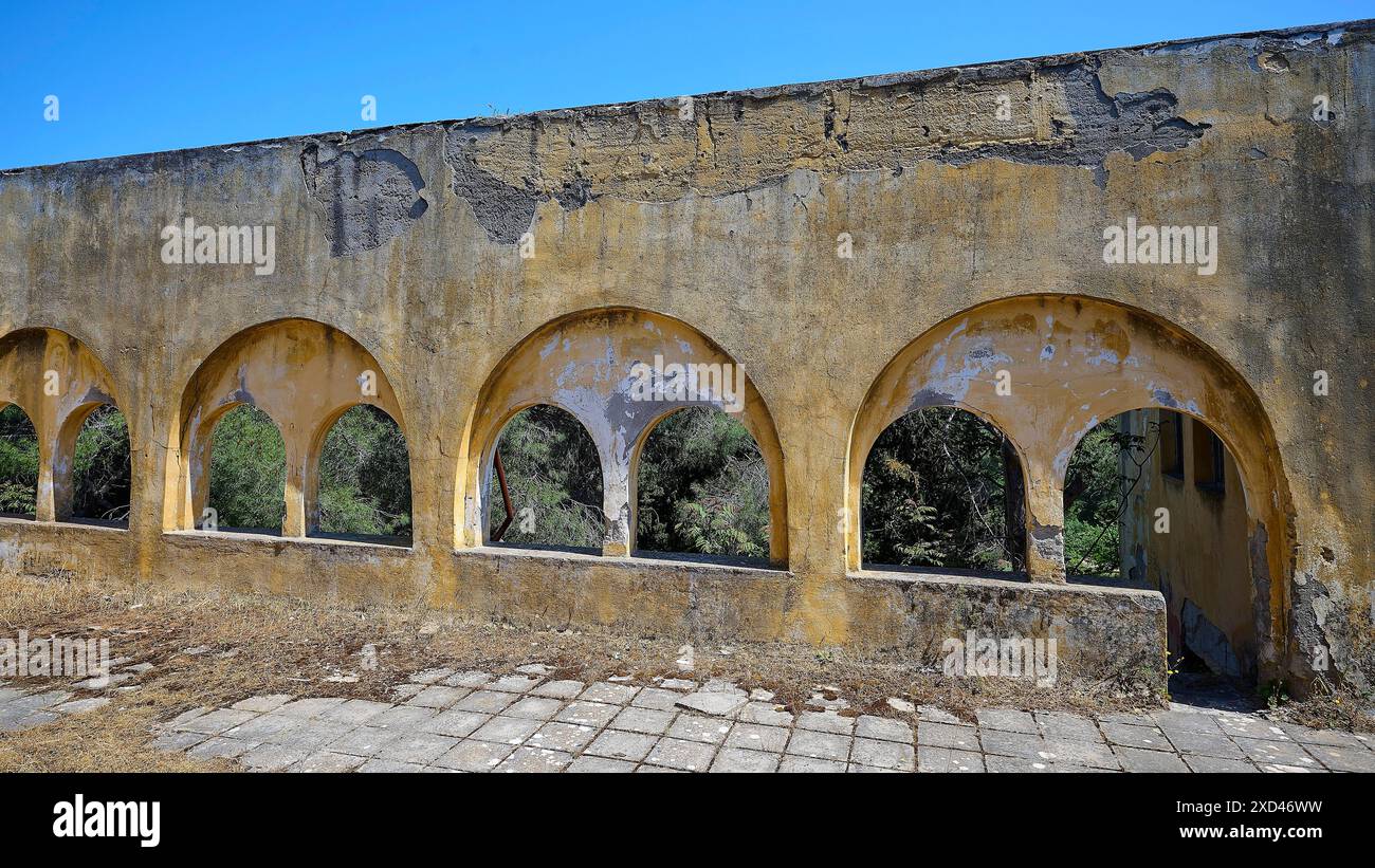 Dilapidated yellow arches in the exterior of a ruined building with ...