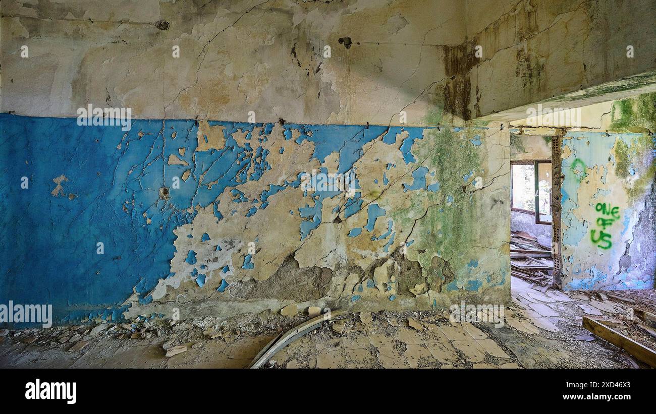 Blue and white peeling wall in a dilapidated room with partially ...