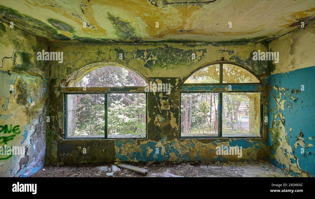 Dilapidated arched windows in an abandoned building with traces of ...
