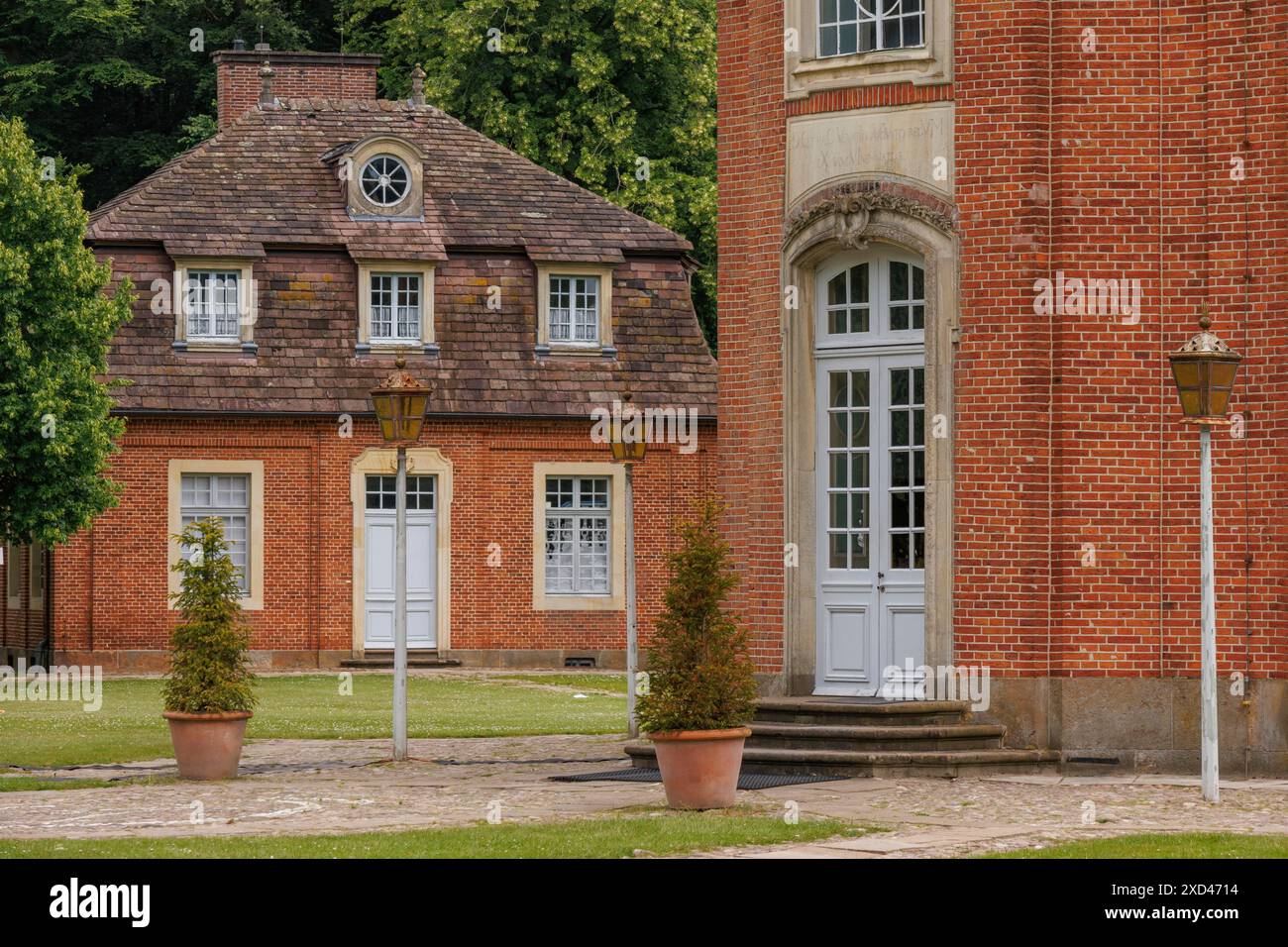 Historic brick building with white windows and doors, surrounded by ...