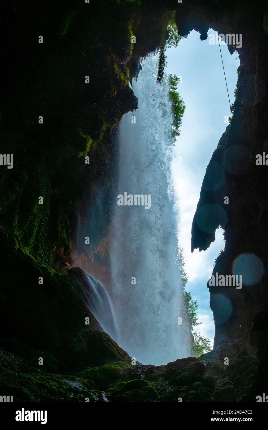 Inside the waterfall in the Iris Grotto at the Cola de Caballo ...