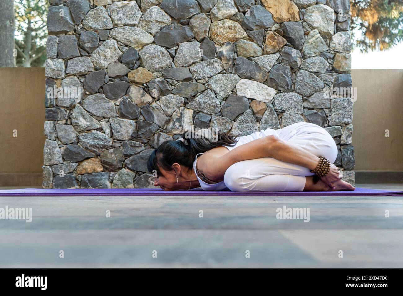 Side view of a woman practicing yoga outdoors Stock Photo - Alamy