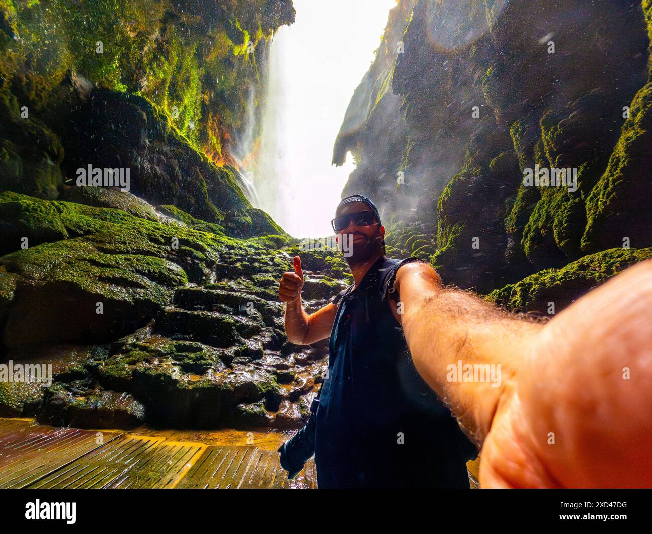 A tourist inside the Iris grotto at the Cola de Caballo Waterfall in ...