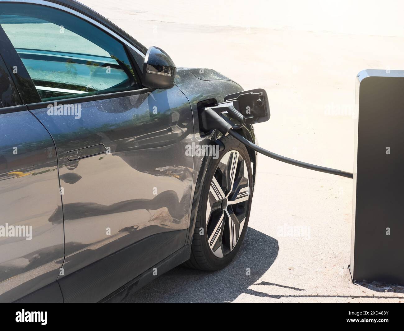 An electric car charging at the Electric vehicle charging station in ...