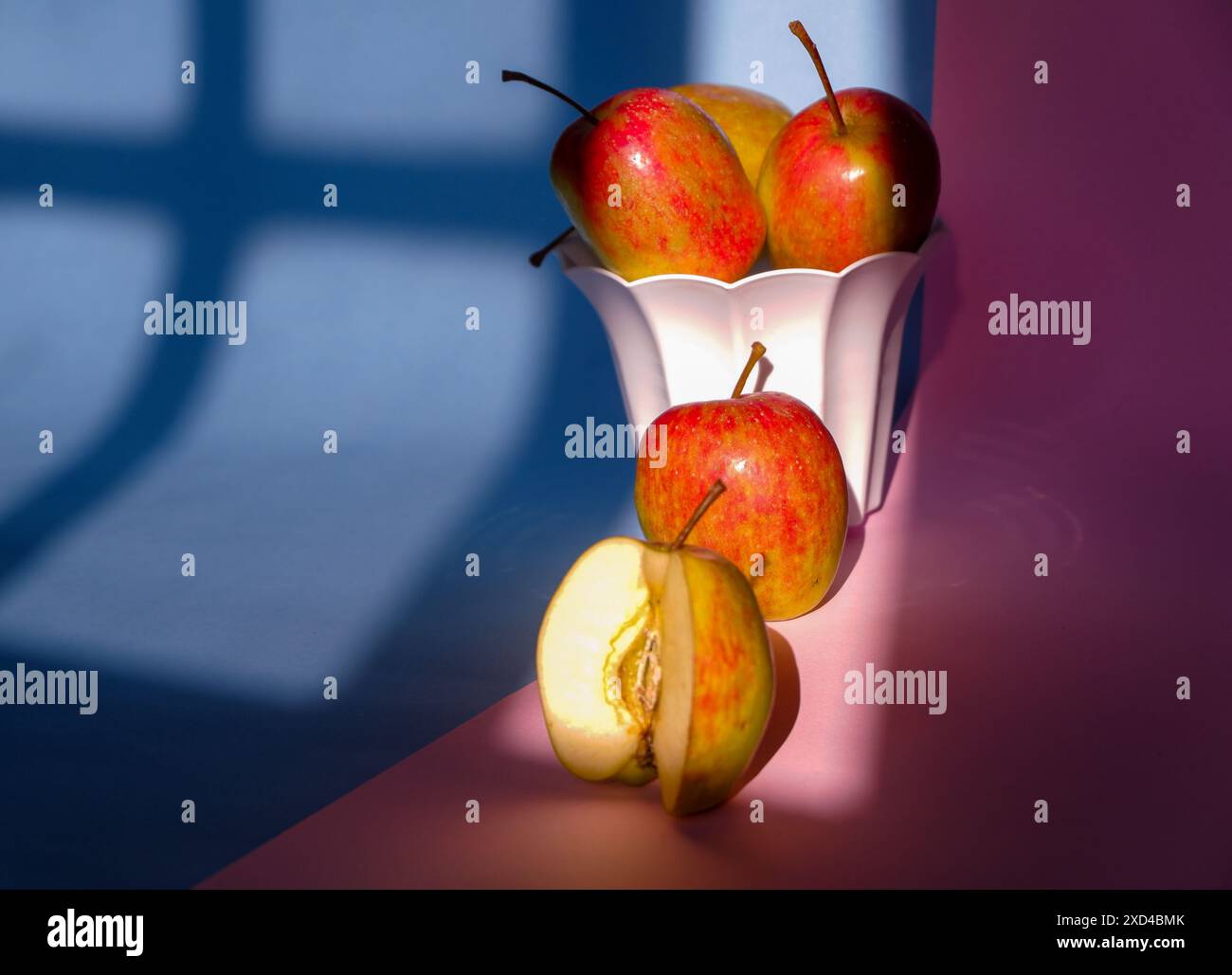 Photo of an apple in a container on a pink and blue background Stock ...