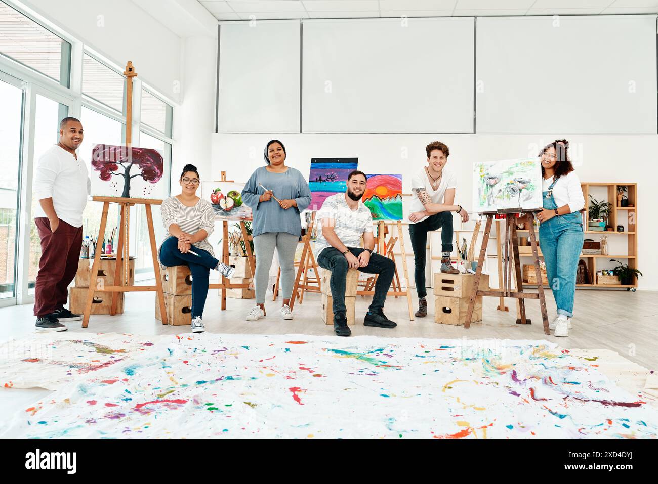 Portrait, group and artists in studio with painting, paintbrush and ...