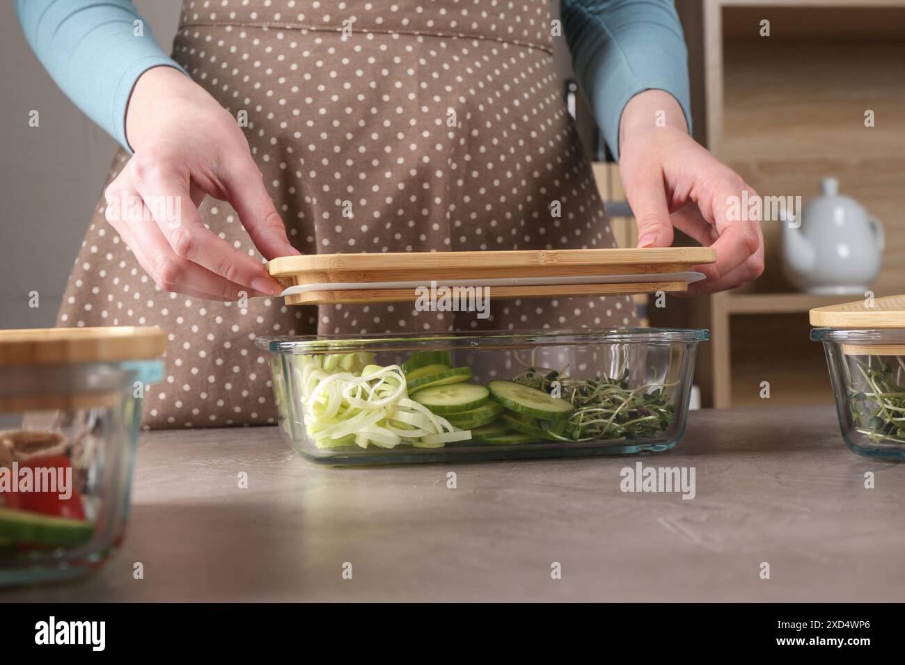 Healthy food. Woman closing glass container with fresh vegetables at ...