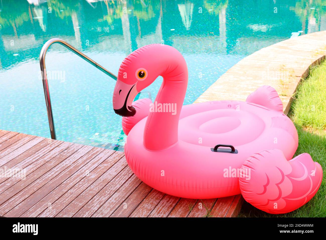 Float in shape of flamingo on wooden deck near swimming pool at luxury ...