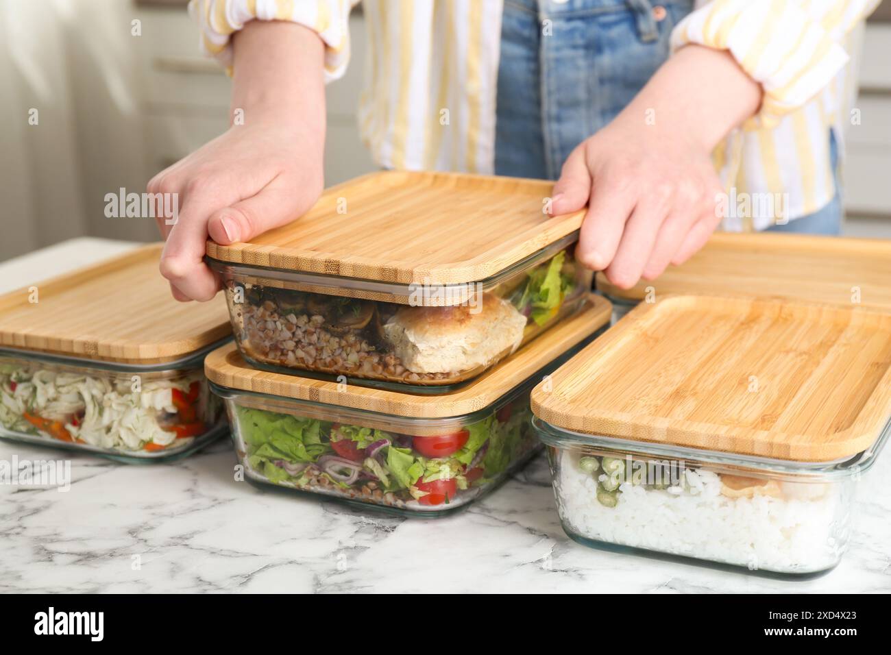 Healthy food. Woman closing glass container with meal at white marble ...