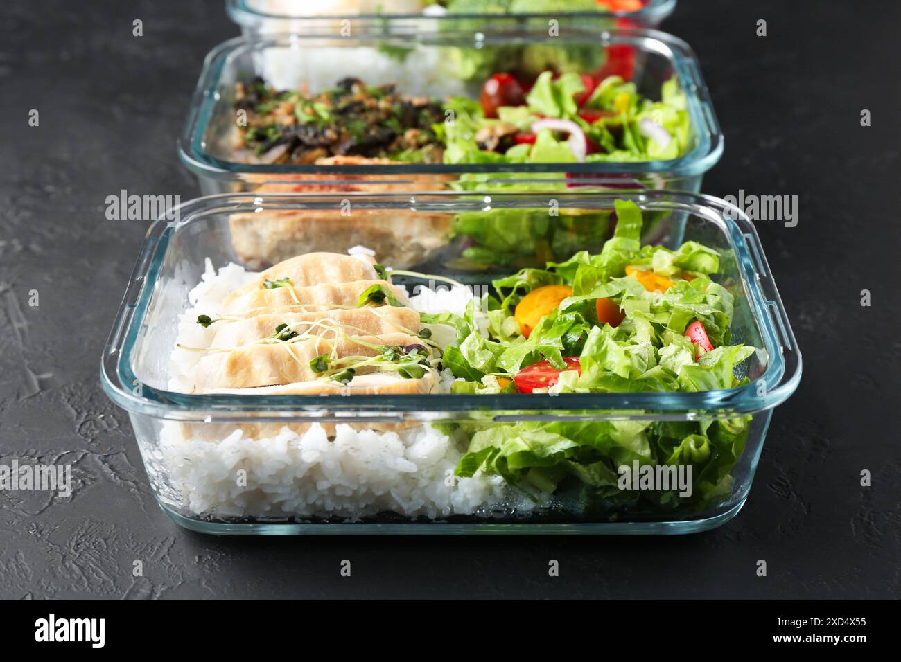 Healthy food. Different meals in glass containers on black table Stock ...