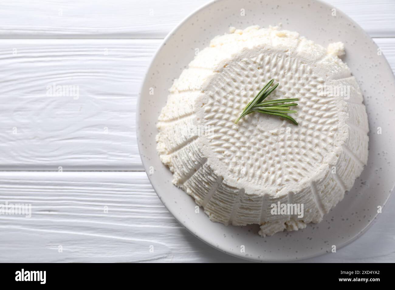 Tasty ricotta (cream cheese) on white wooden table, top view. Space for ...