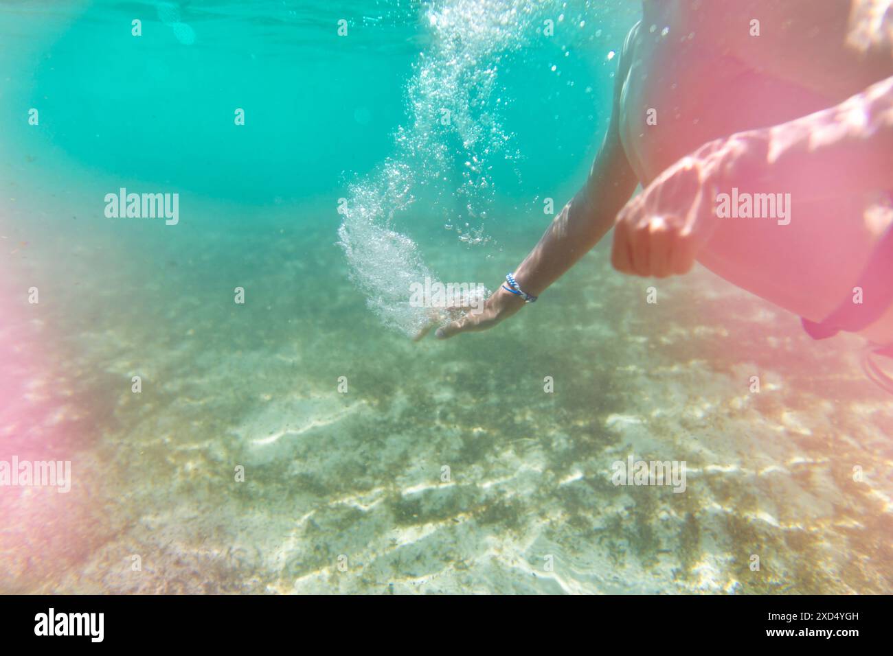 Underwater hand reaching for sunlight, creating a watery burst of ...