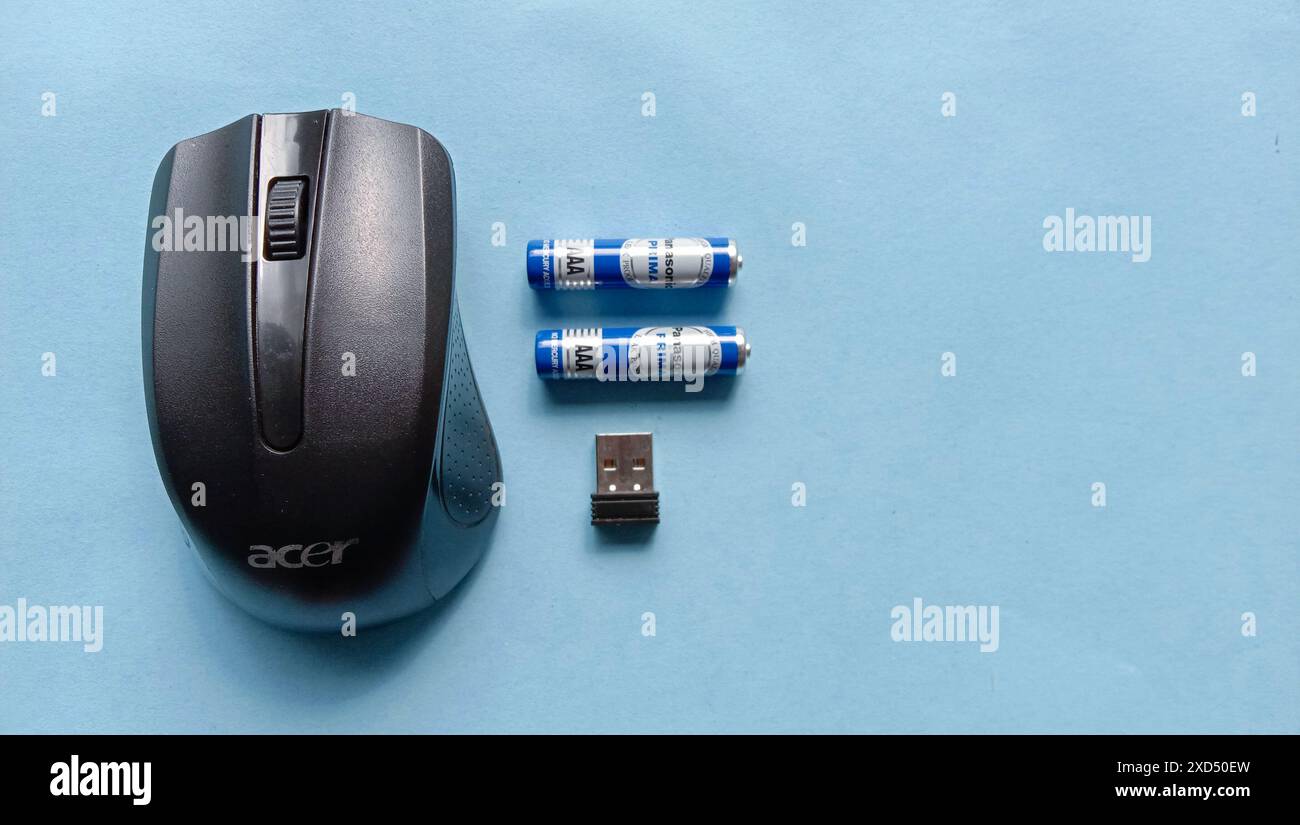 Photo of a wireless mouse with battery and usb next to it on a blue ...