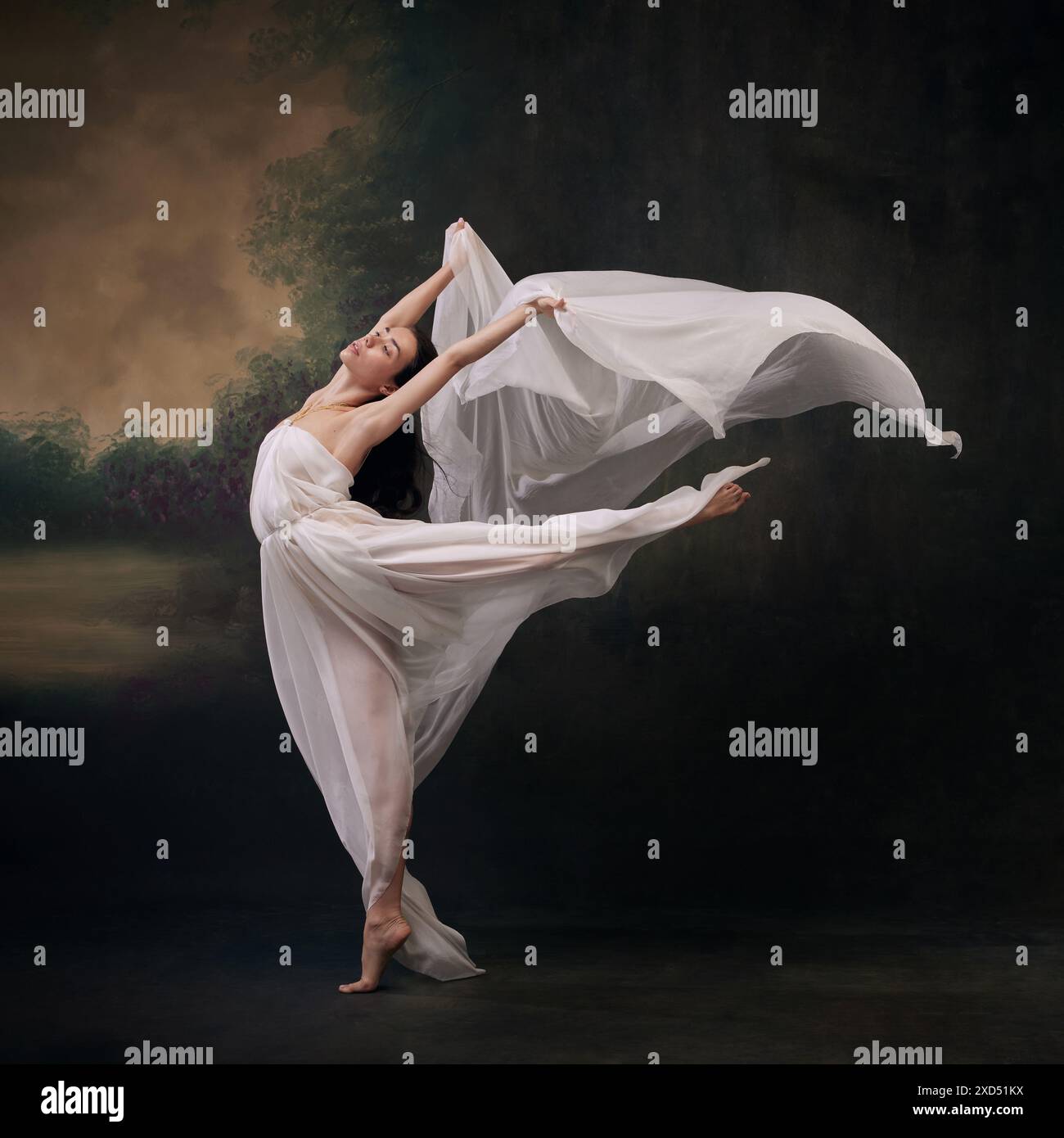 Dancer's leap highlighted by gentle flow of her gown, creating image of ...