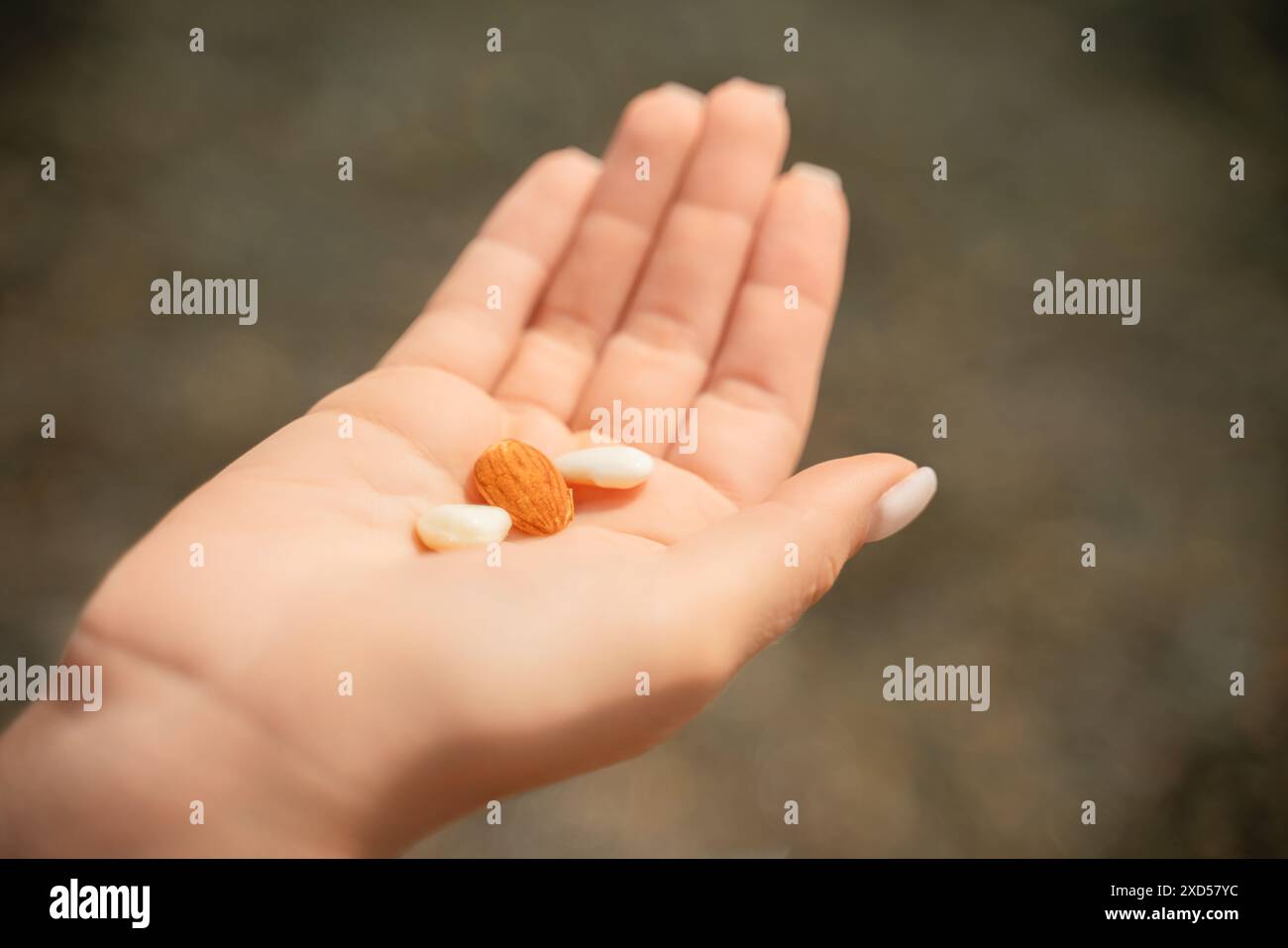 A person is holding a handful of nuts in their hand. The nuts are of ...