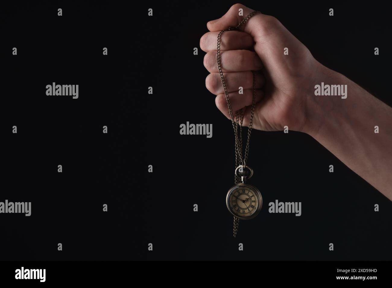 Man holding chain with elegant pocket watch on black background ...