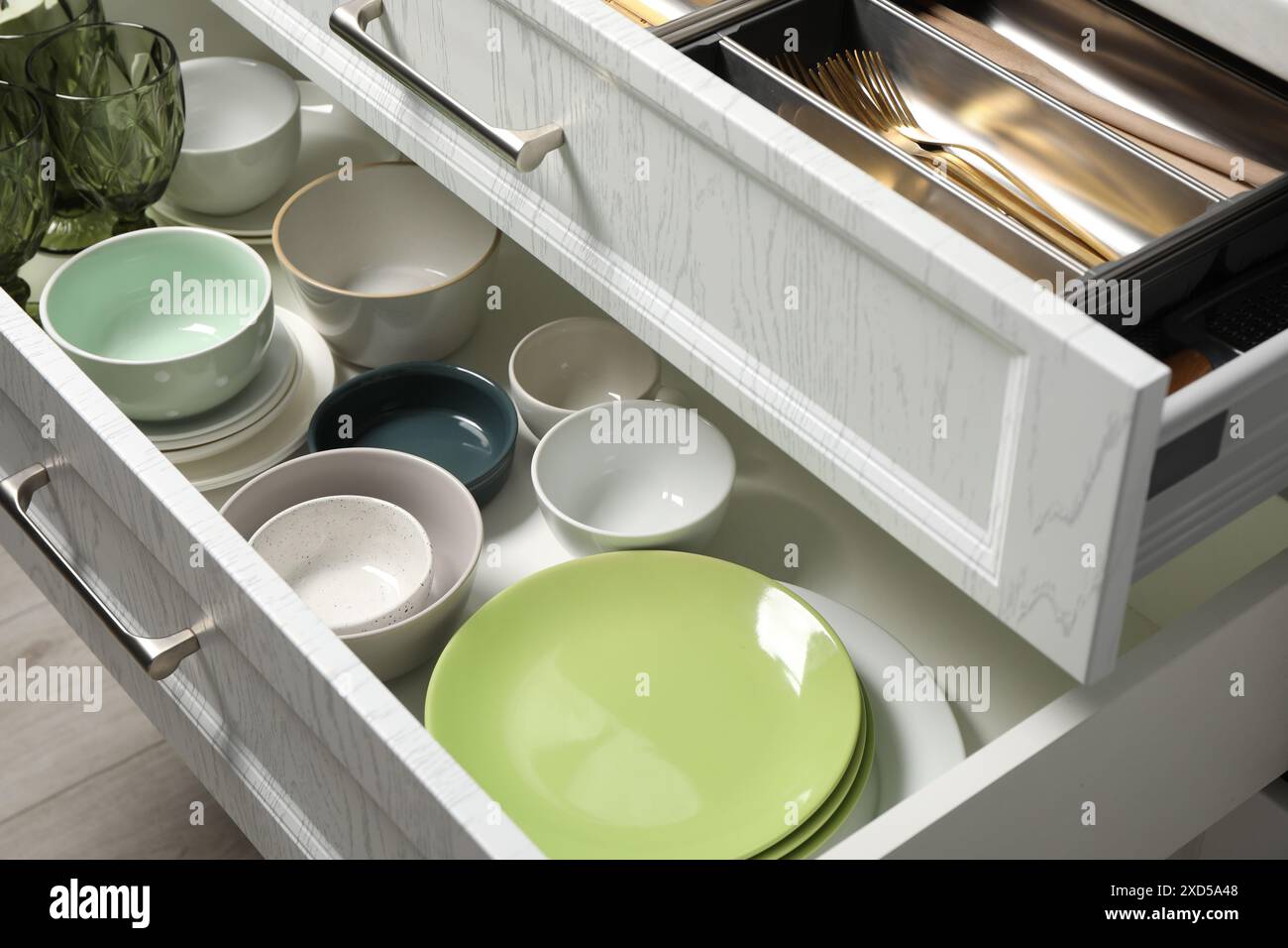 Ceramic dishware and cutlery in drawers indoors Stock Photo - Alamy