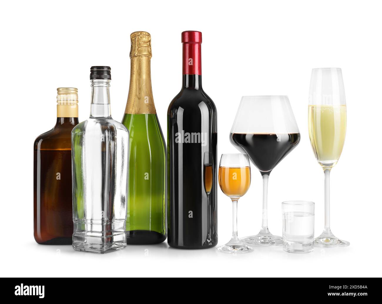 Bottles and glasses with different alcoholic drinks on white table ...