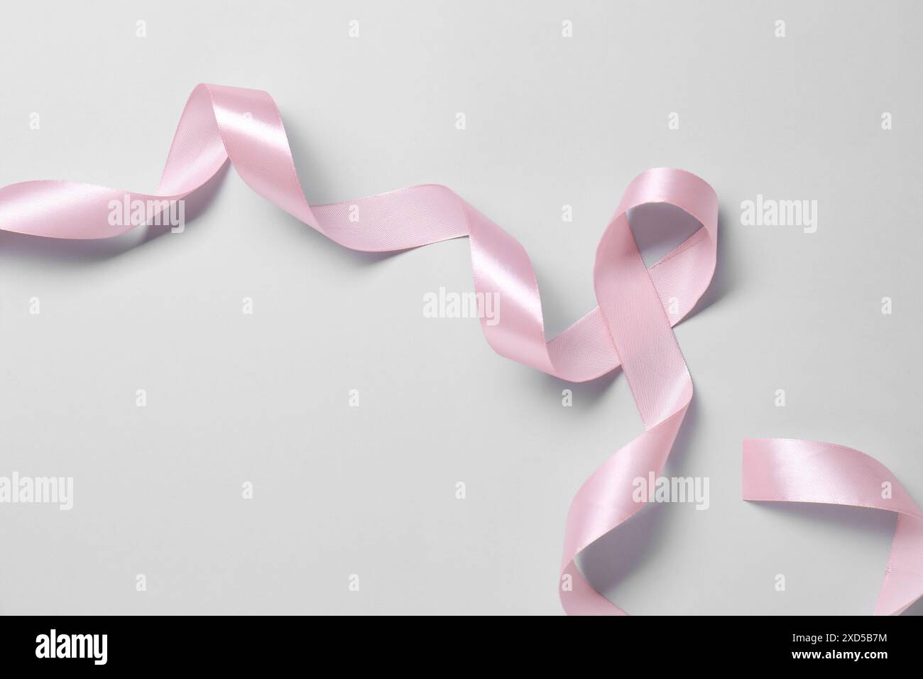 One beautiful pink ribbon on white background, top view Stock Photo - Alamy