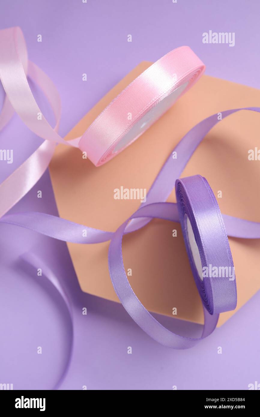 Beautiful ribbon reels and podium on violet background, flat lay Stock ...