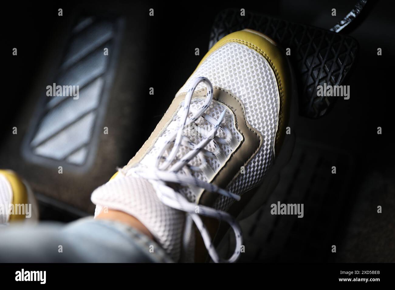 Woman in sneakers pushing on pedal of car brake, closeup Stock Photo ...