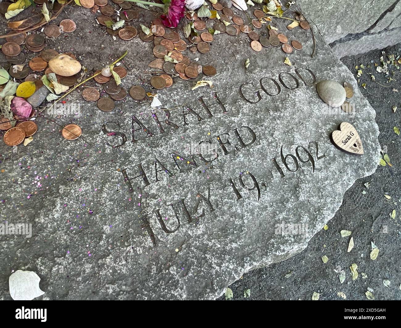 Coins, flowers and offerings lay on the stone memorial to Sarah Good, a ...