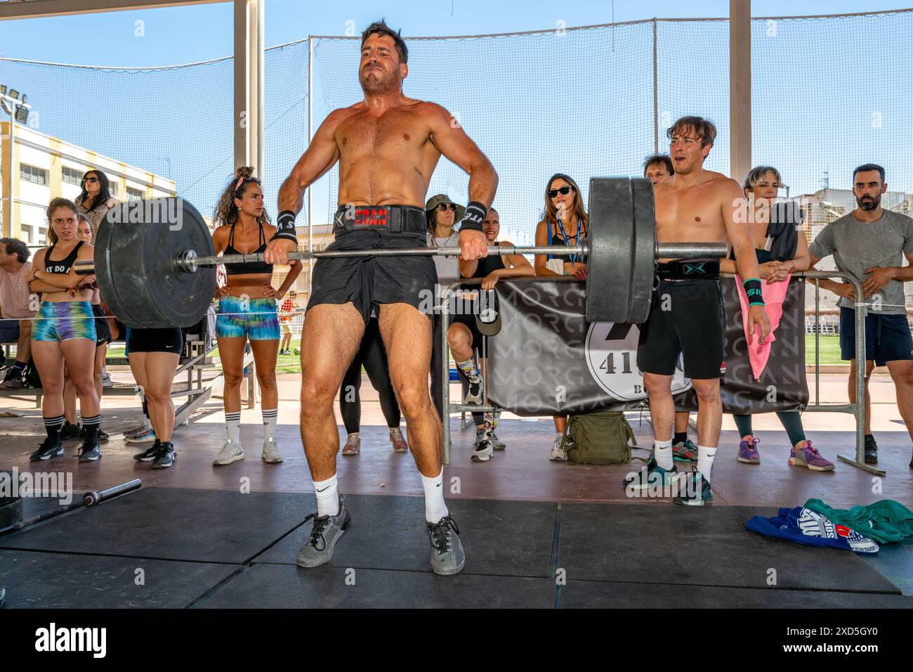 Athletes performing weightlifting in an intense CrossFit competition ...