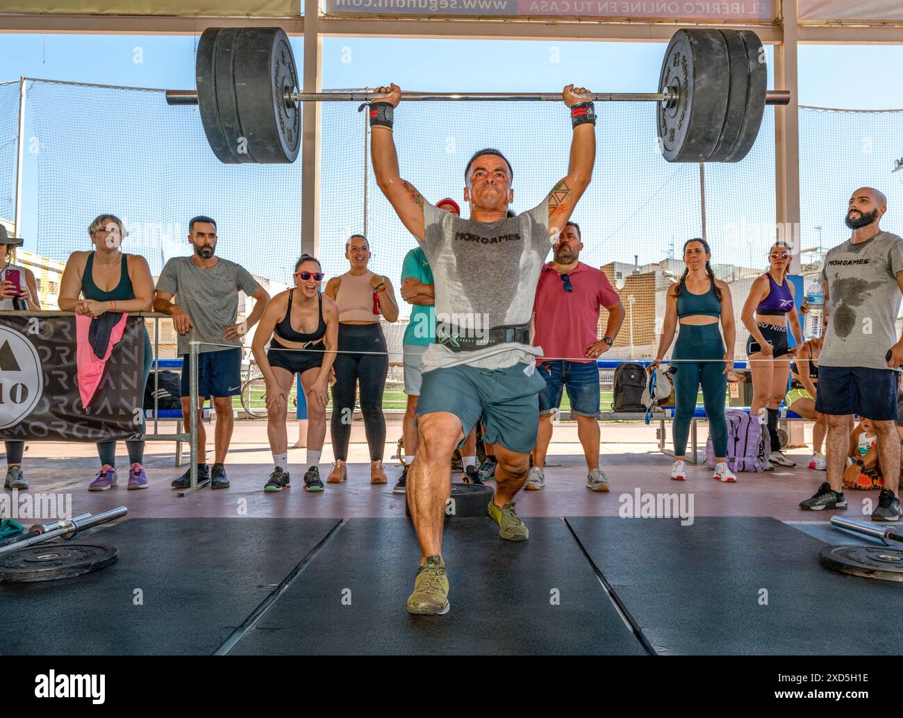 Athletes performing weightlifting in an intense CrossFit competition ...