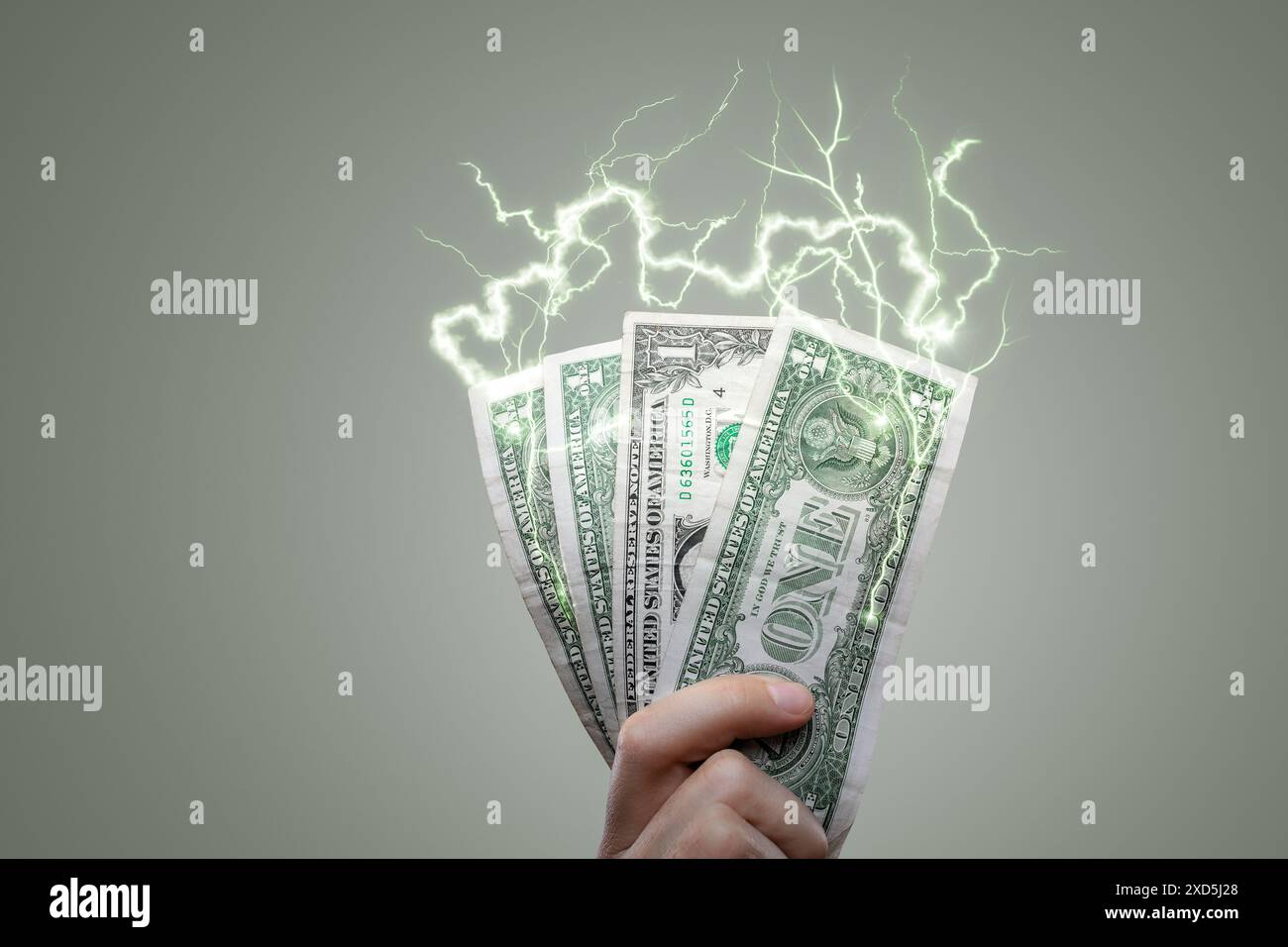 Electricity Emitting from Dollar Bills Held by a Hand Stock Photo - Alamy