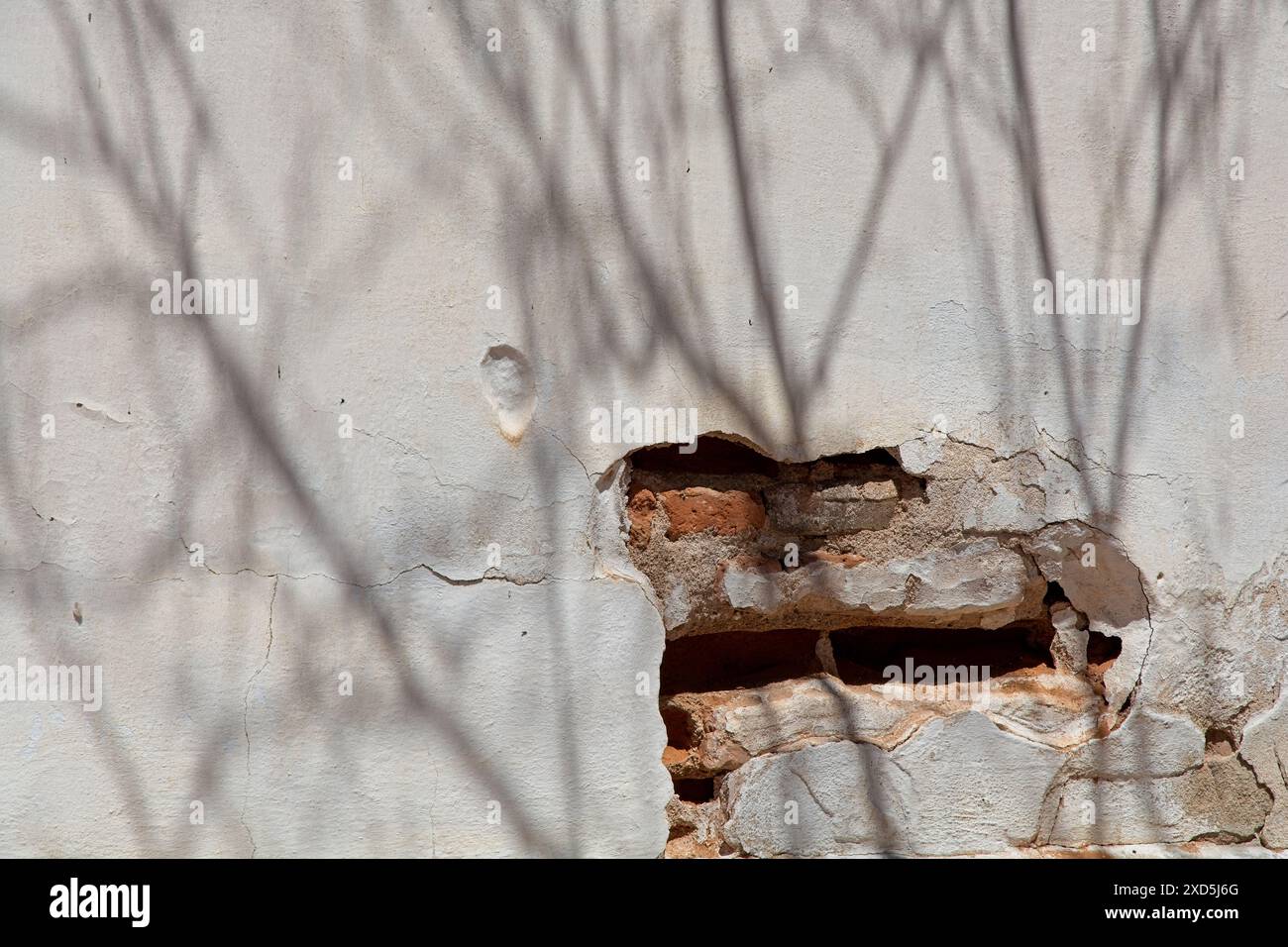 Exposed adobe brick construction behind stucco covered wall Stock Photo ...