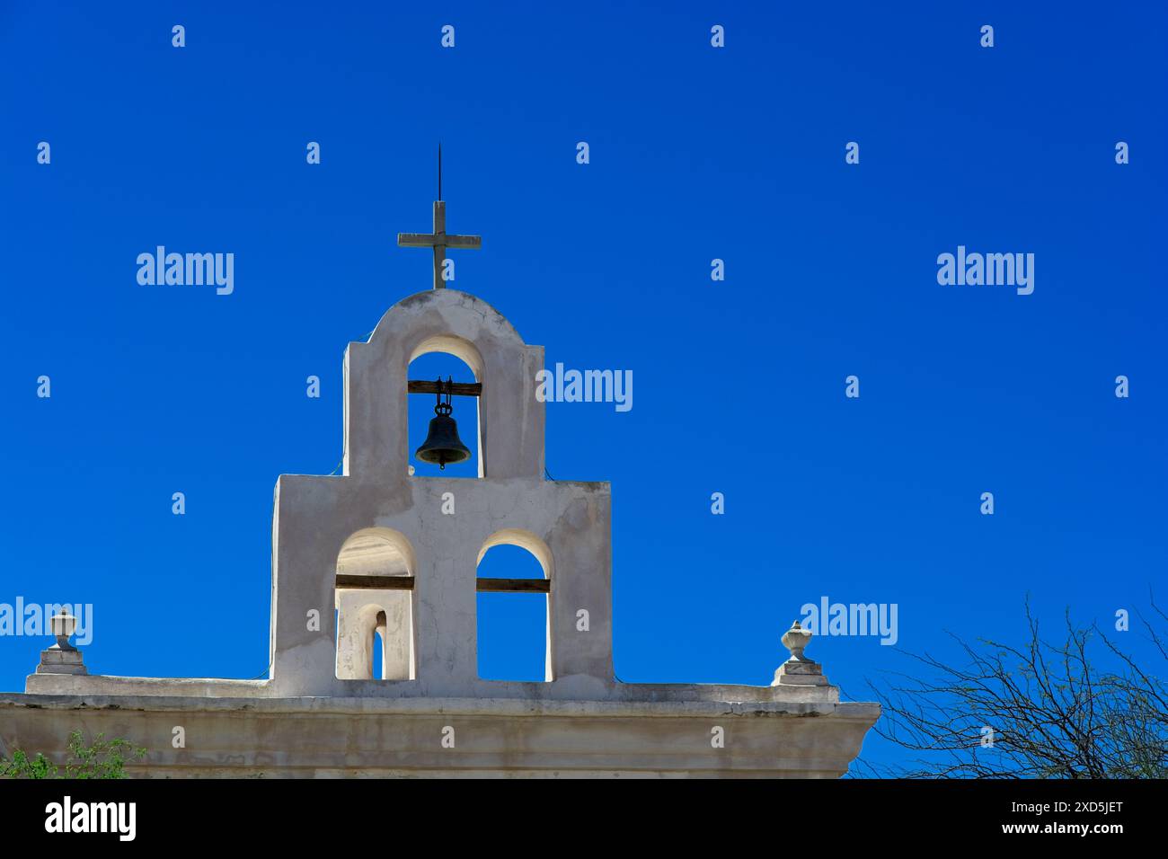 Bell tower and cross atop mortuary chapel adjacent to San Xavier del ...
