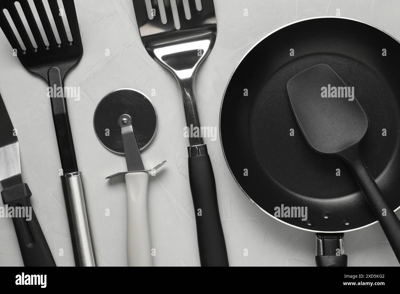 Different spatulas and other kitchen utensils on grey background, flat ...