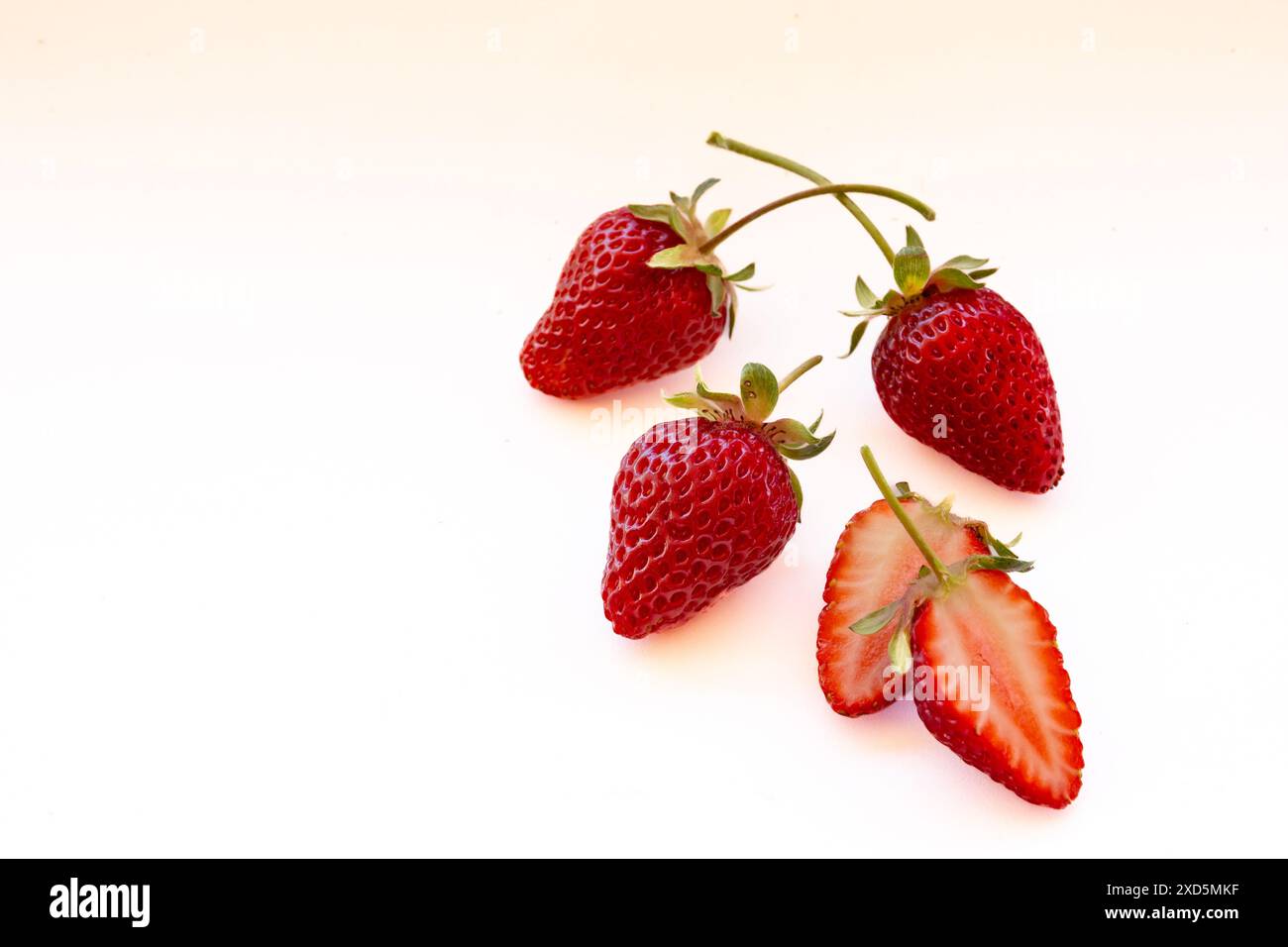 Three whole handpicked organic strawberries and one cut in half ...