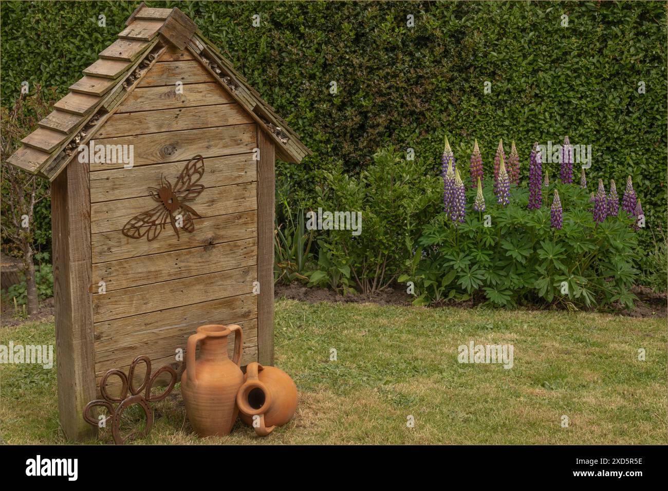 Oversized bug house with lipins in the background and various garden ...