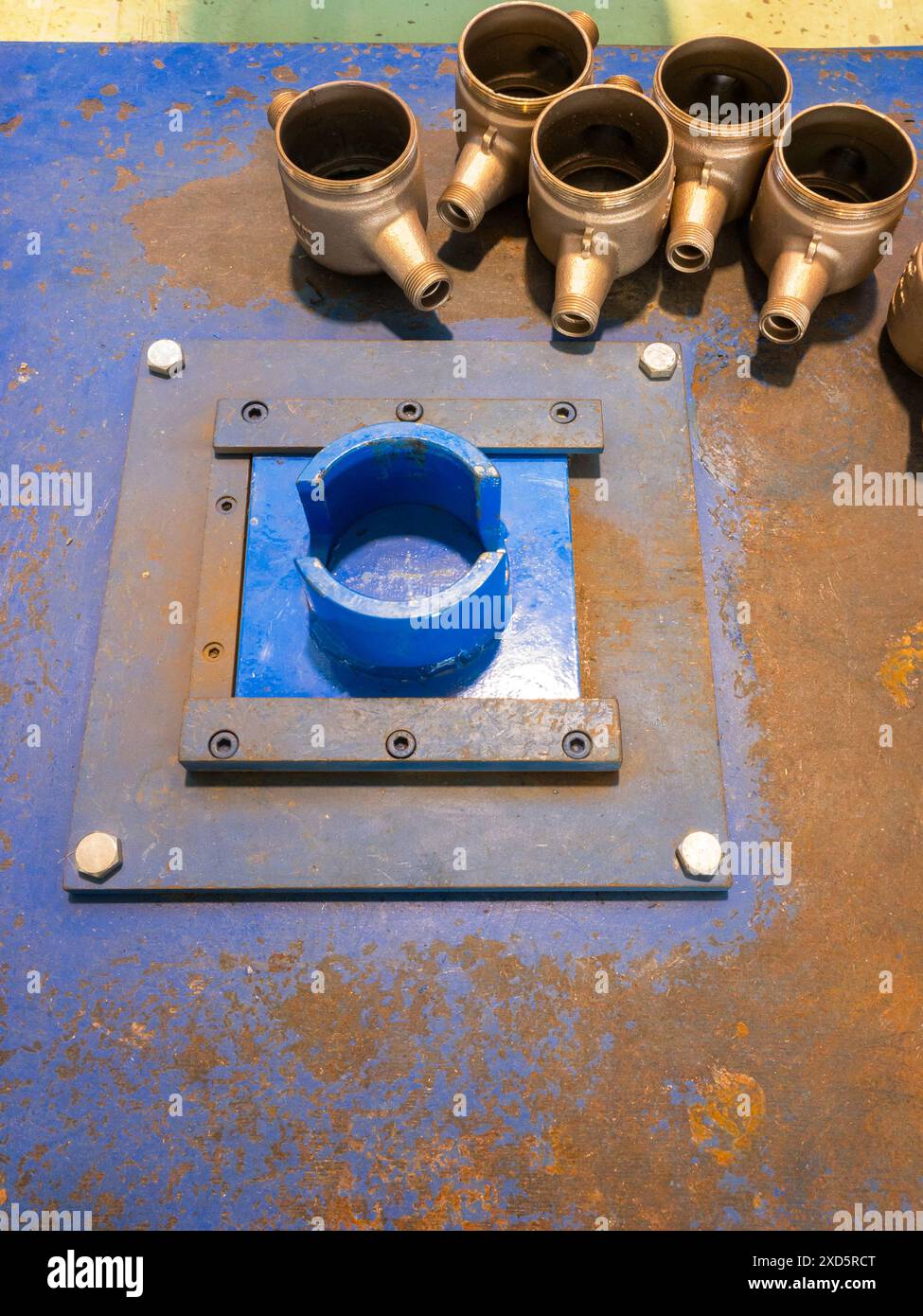 The brass frame of a water meter waiting to be repaired on a table in ...