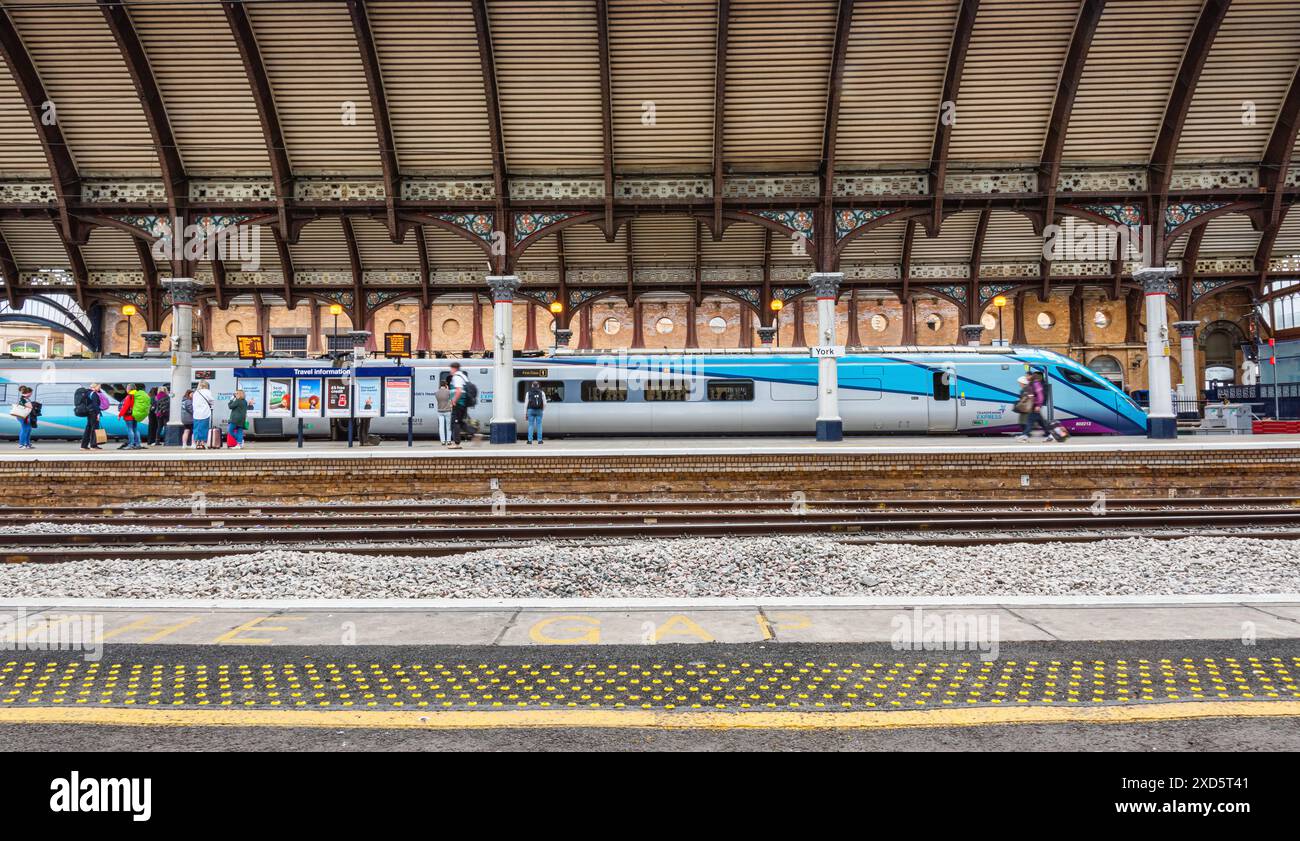 A train stands by a 19th Century historic canopy preparing to depart. A ...