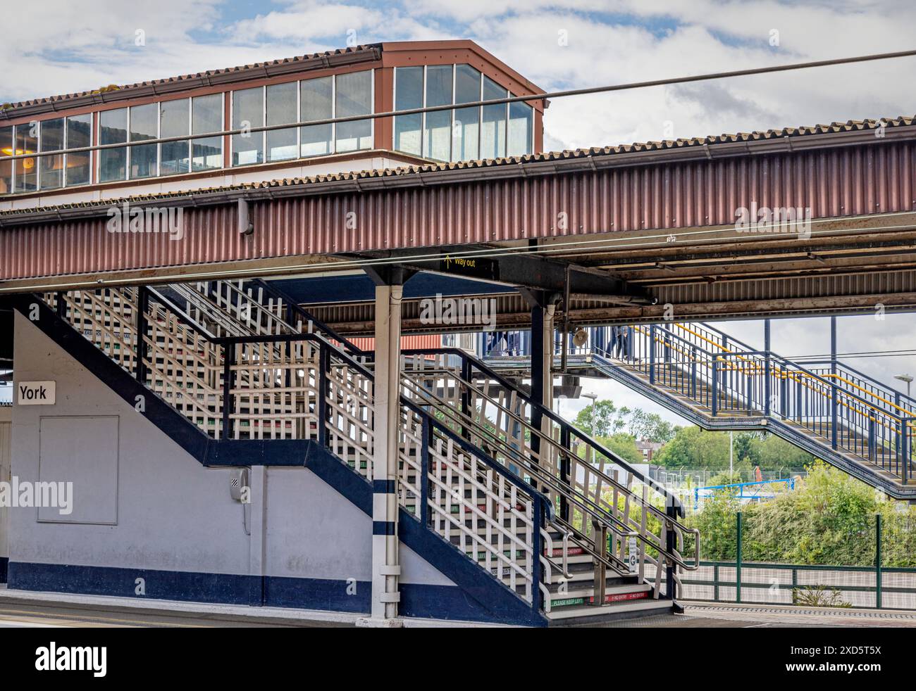Two staircases at a railway station platform covered by a metal canopy ...