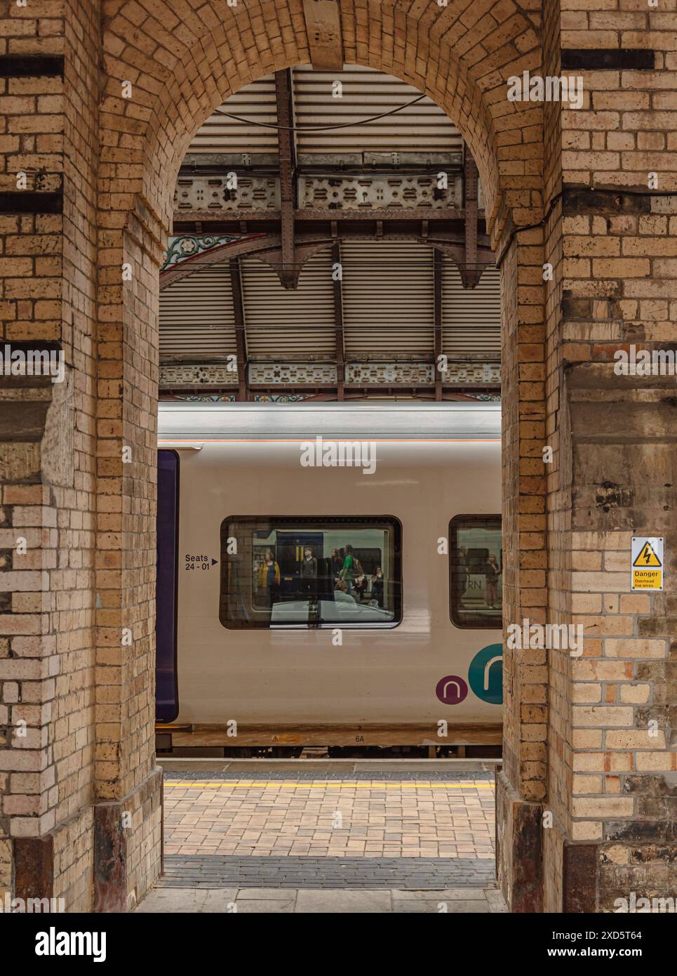 A railway station platform and a carriage can be seen through a brick ...