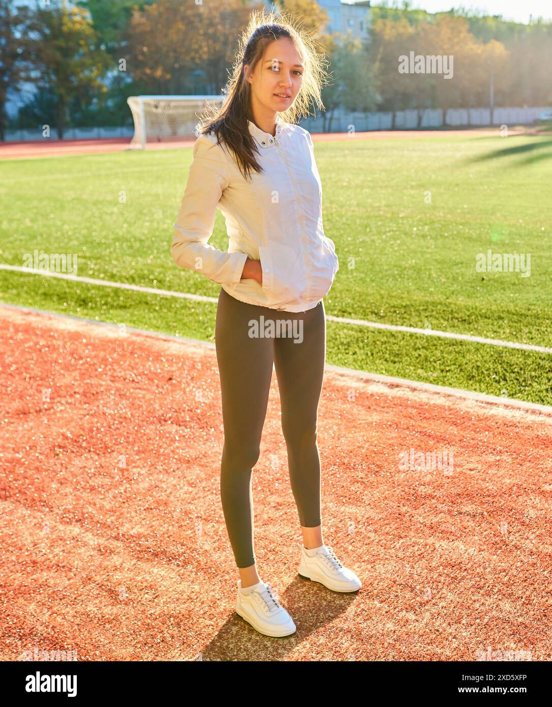 Sports girl doing stretching on the stadium lawn Stock Photo - Alamy